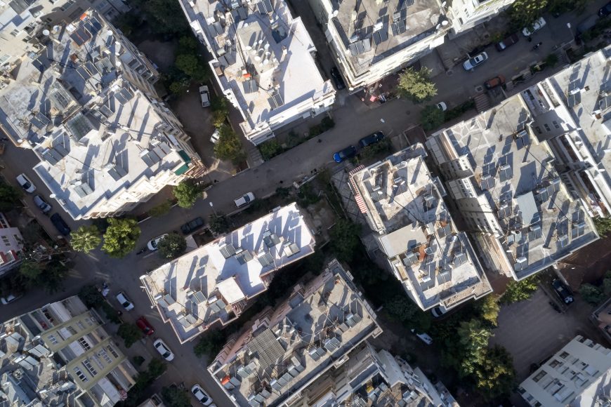 Aerial view of roofs of high-rise buildings with solar panels ...